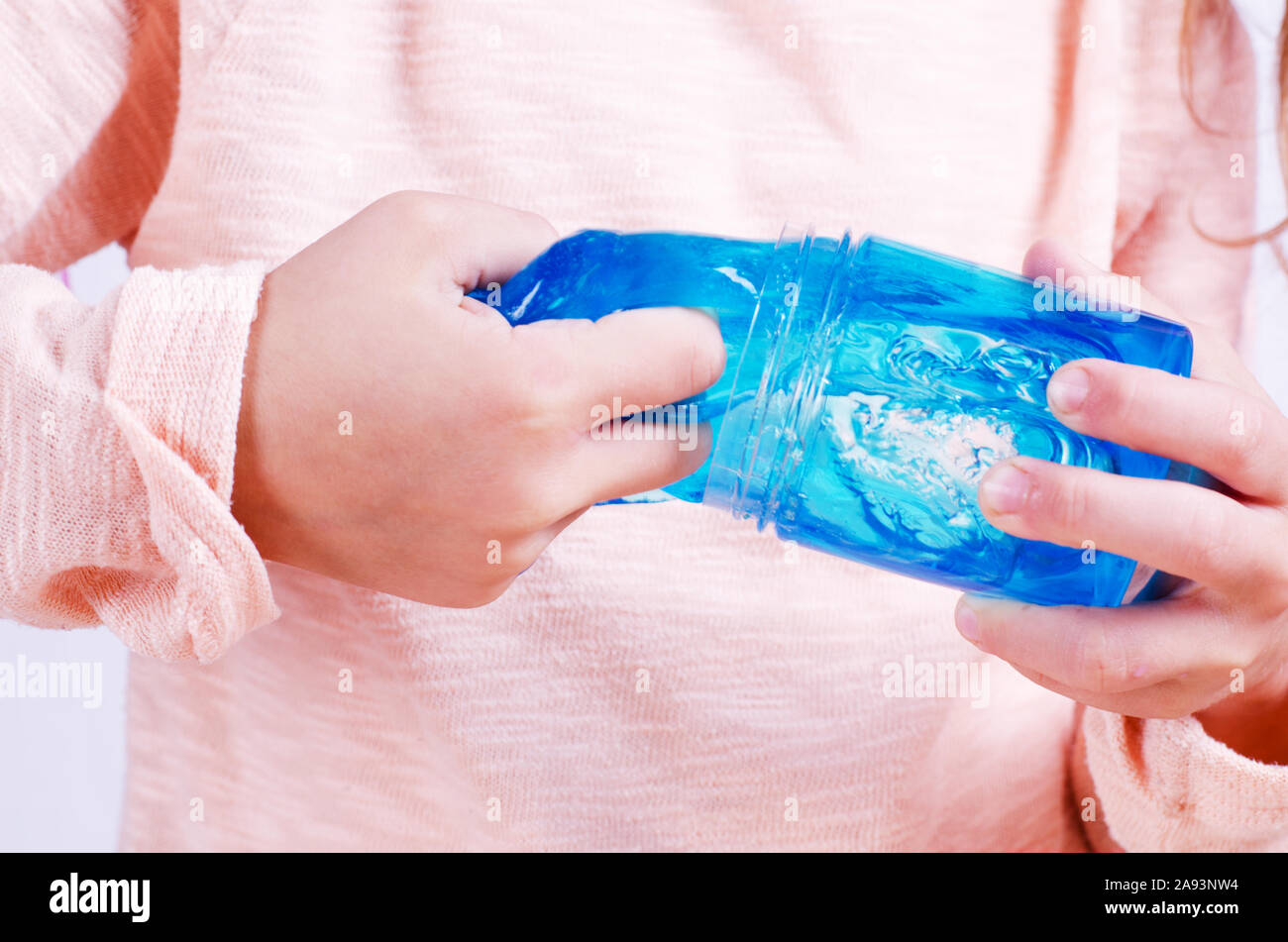 Adorable caucasian little girl holding slime toy, worldwide popular ...