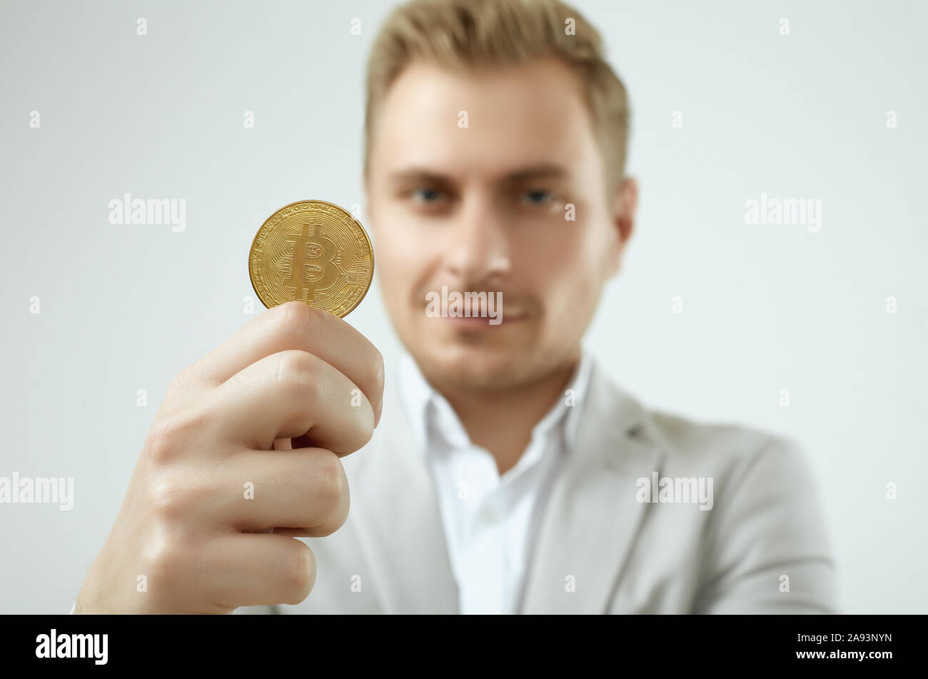 Portrait of a handsome blonde man model in a fashion gray suit holds a ...