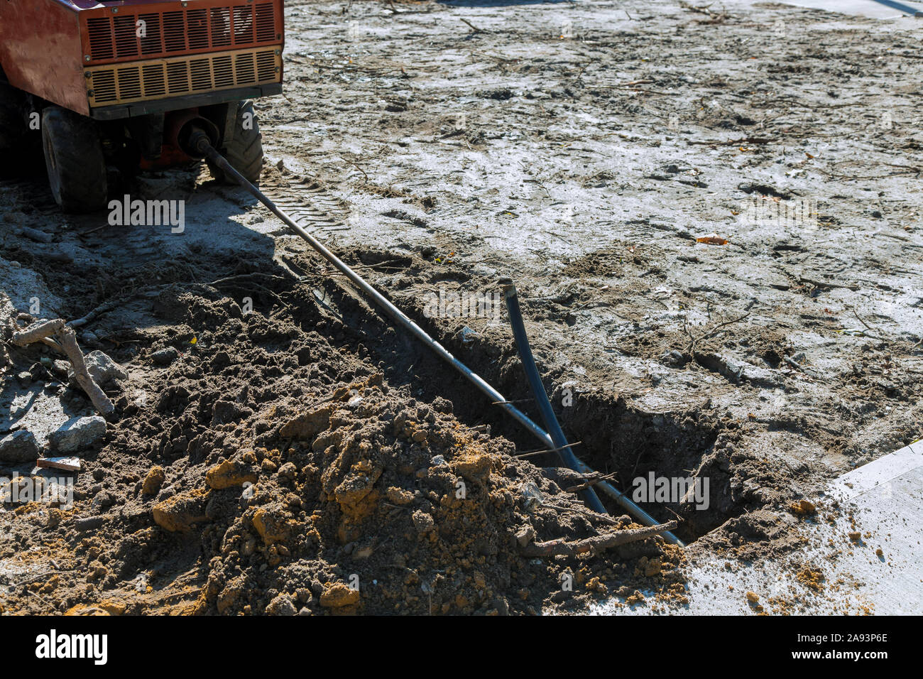 Digging a pipe in the workers installing irrigation for water plants ...