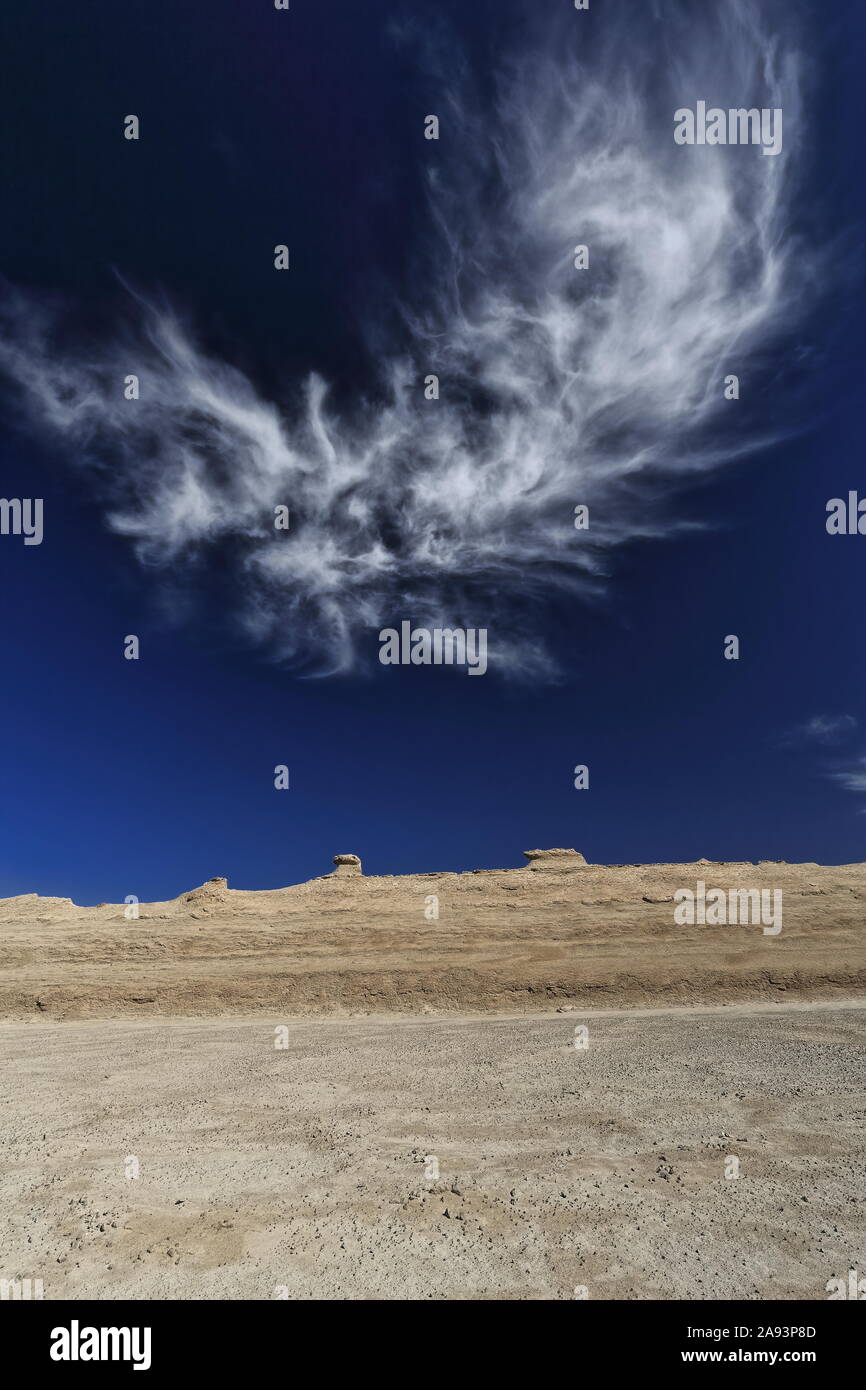 Cirrus uncinus cloud over wind-eroded horse head-shaped yardangs ...