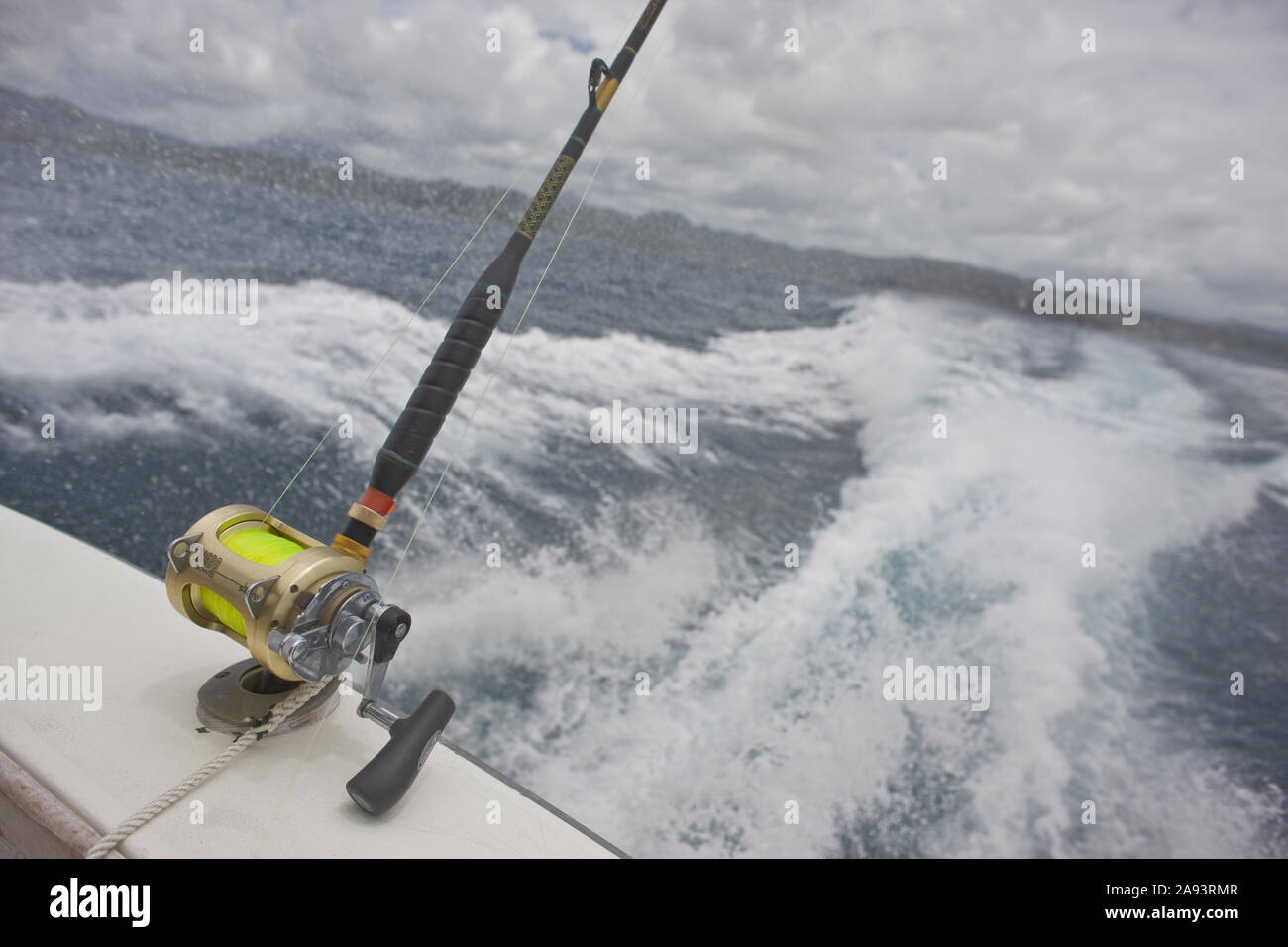 Single fishing rod secured to the back of a boat out in the ocean Stock ...