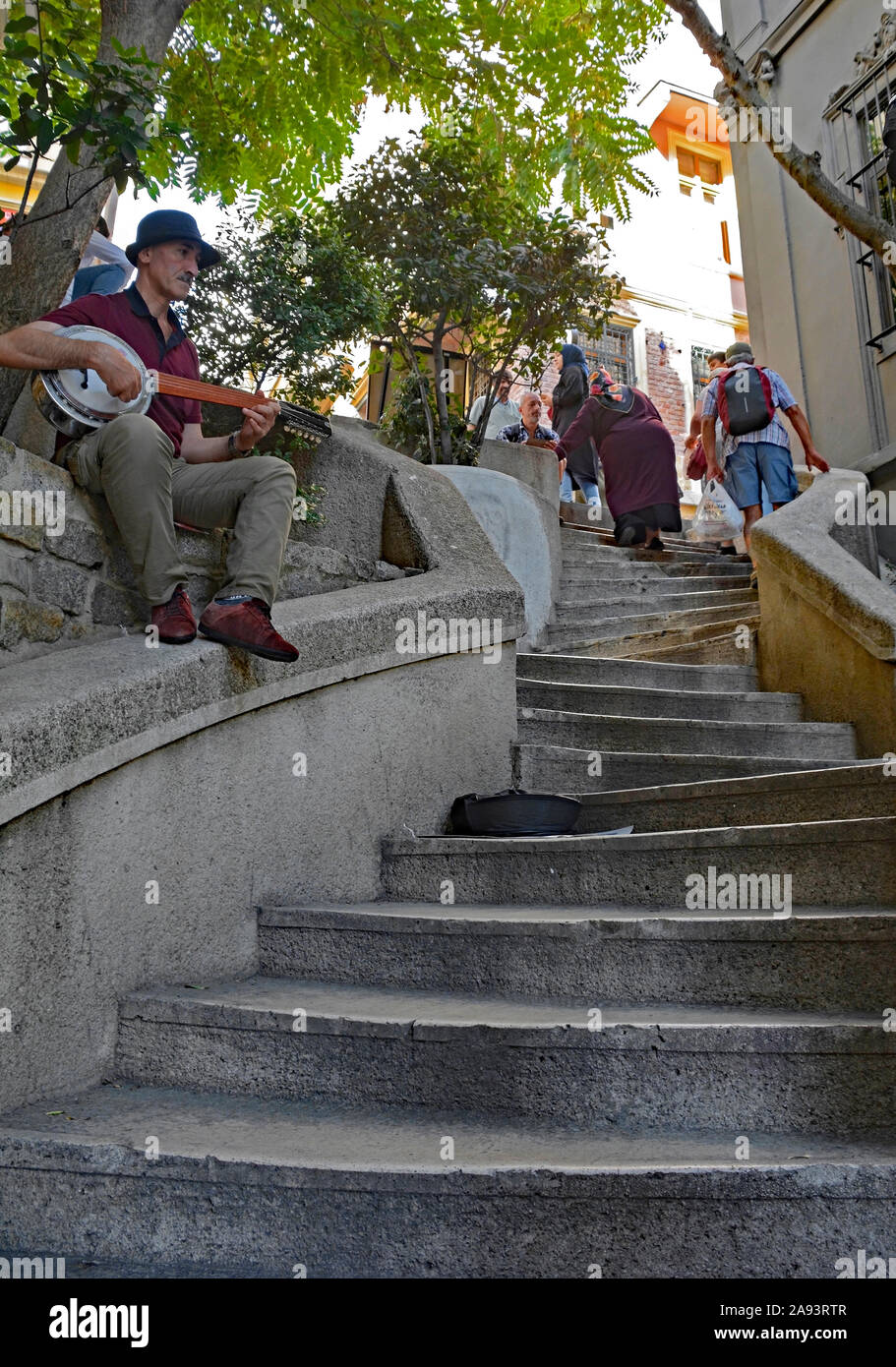 Istanbul,Turkey-September 8th 2019.A busker plays a 12 string cumbus ...