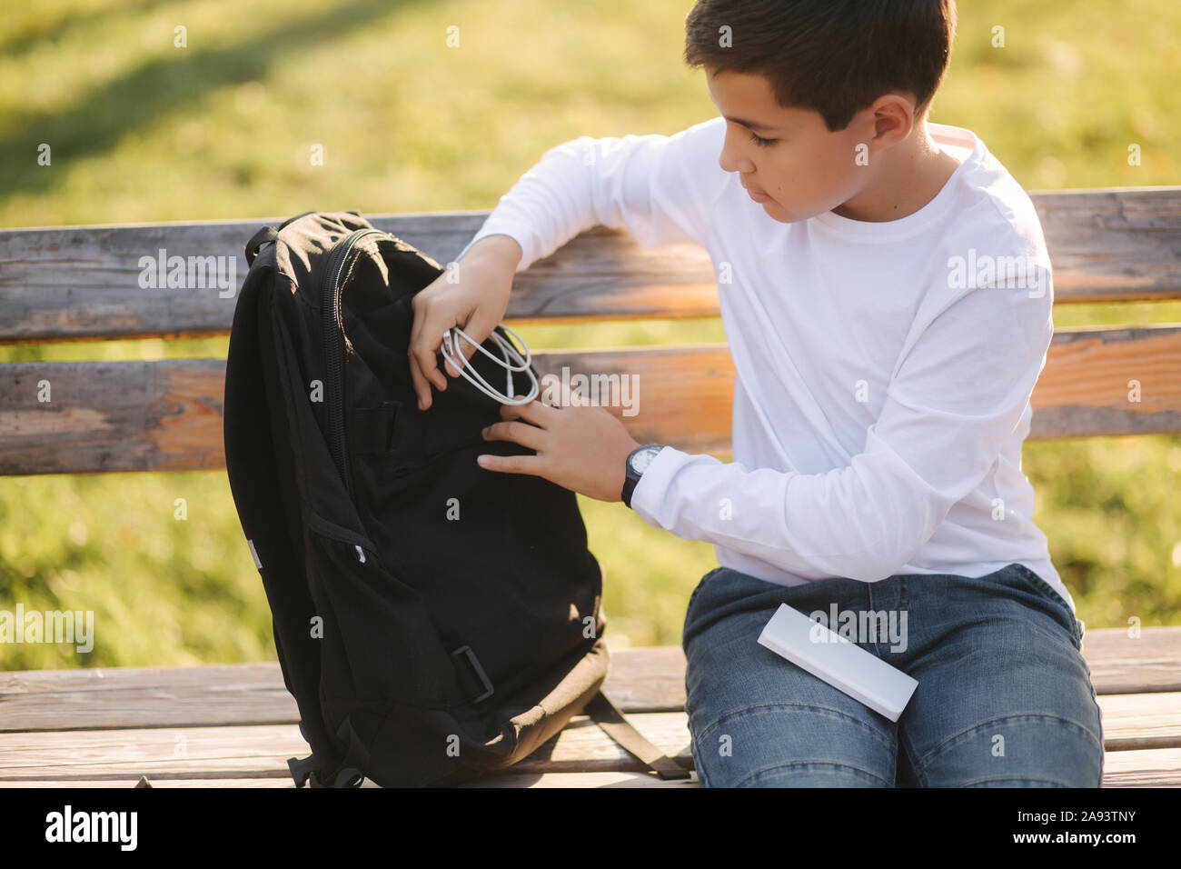 Handsome teenage boy take from his backpack powerbark for charging ...
