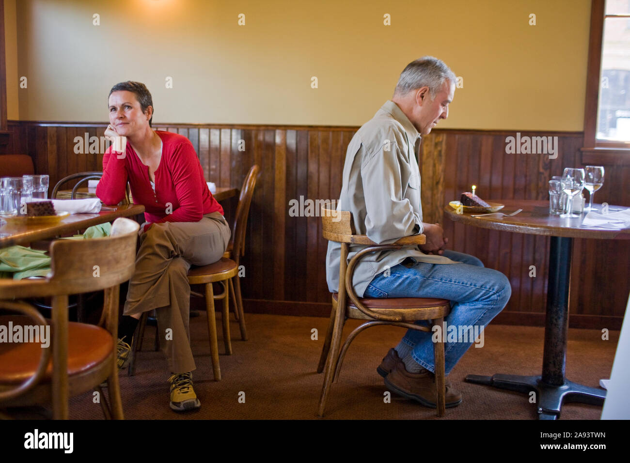 Unhappy couple sitting at separate tables inside a restaurant Stock ...