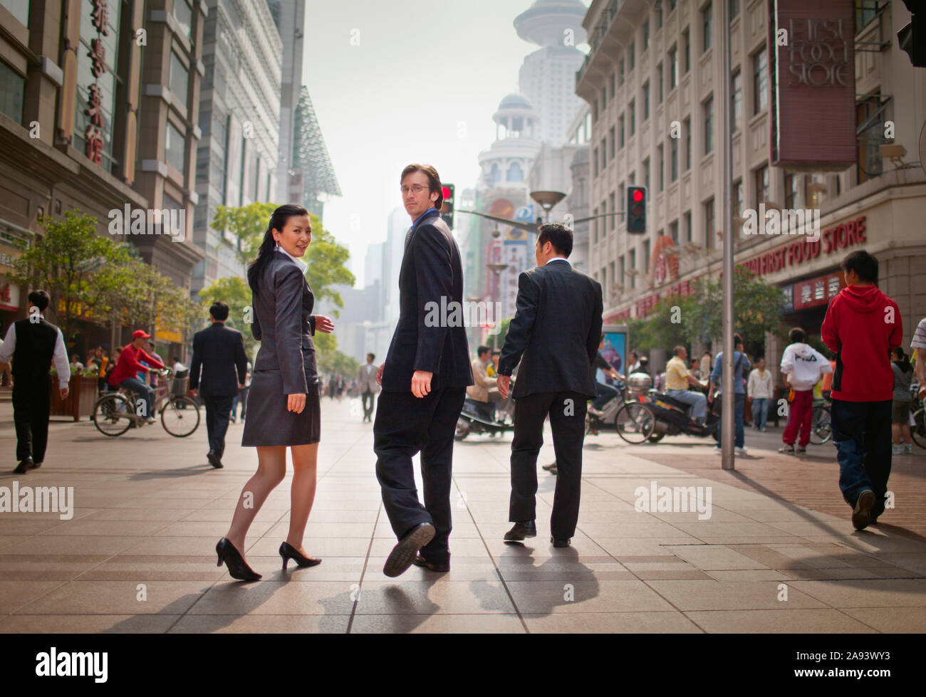 Businessman and woman looking over their shoulders in a city street ...