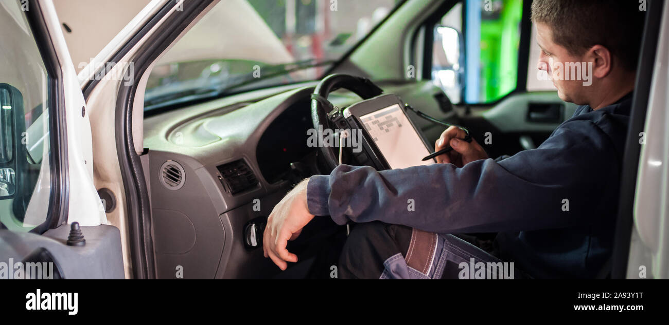 Automobile computer diagnosis. Car mechanic repairer looks for engine ...