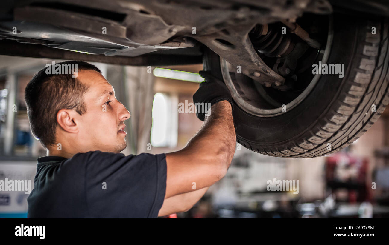 Master auto mechanic repairer service technician checking the condition ...