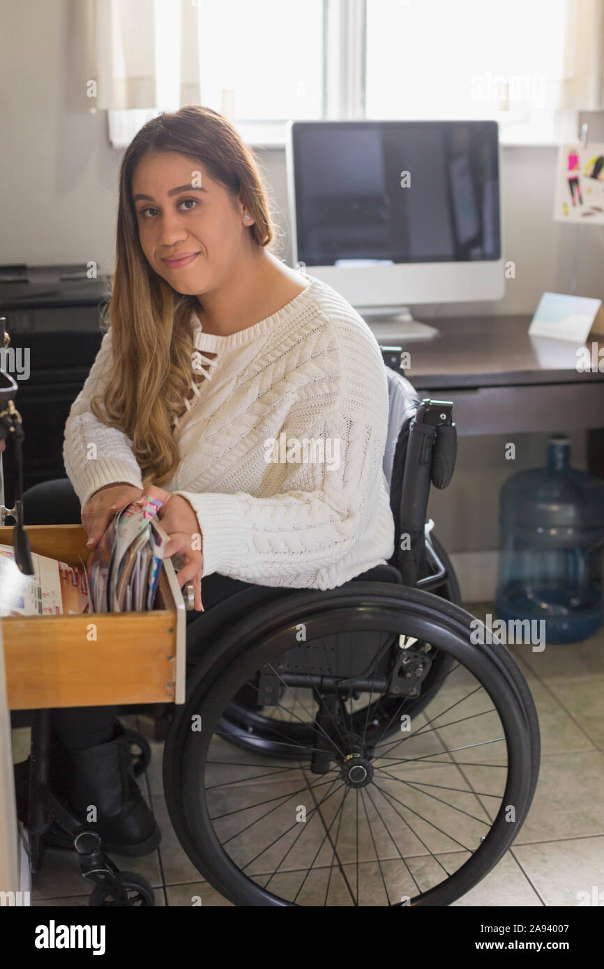 Woman with Spinal Cord Injury arranging things in her room Stock Photo ...