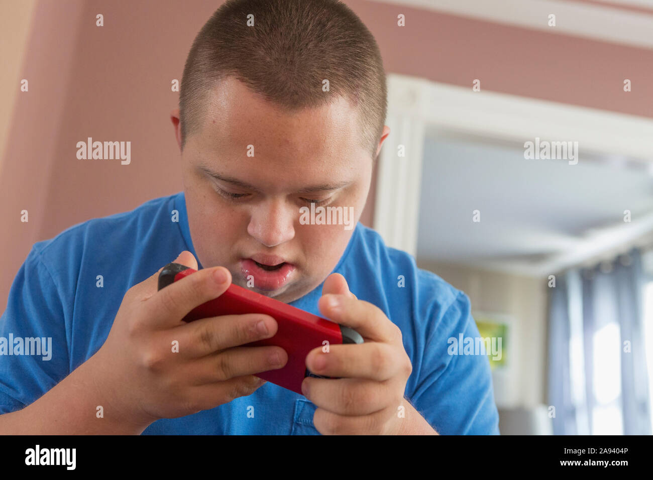 Teen with Down Syndrome holding his phone Stock Photo - Alamy