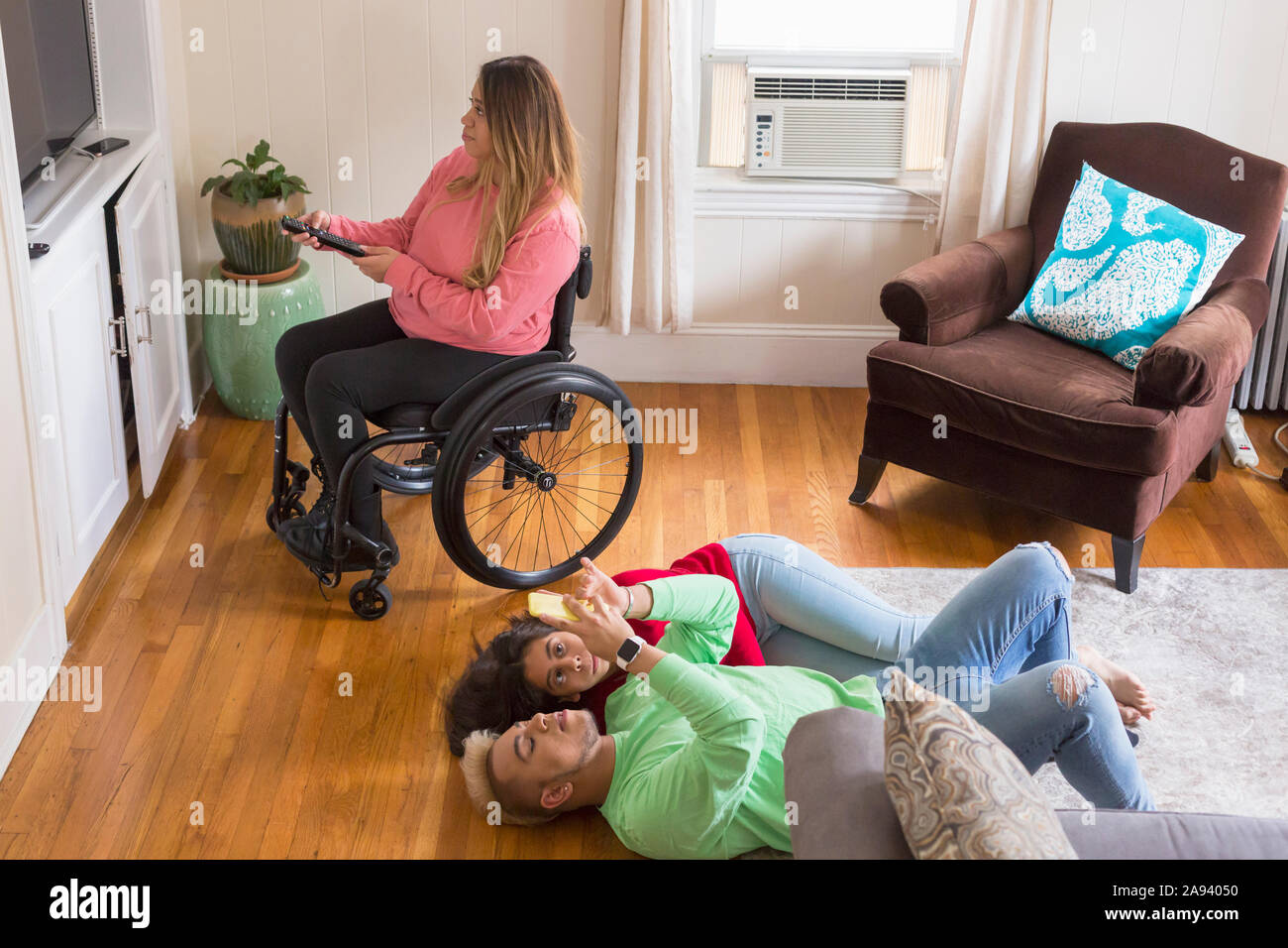 Woman with Spinal Cord Injury using the TV remote Stock Photo - Alamy