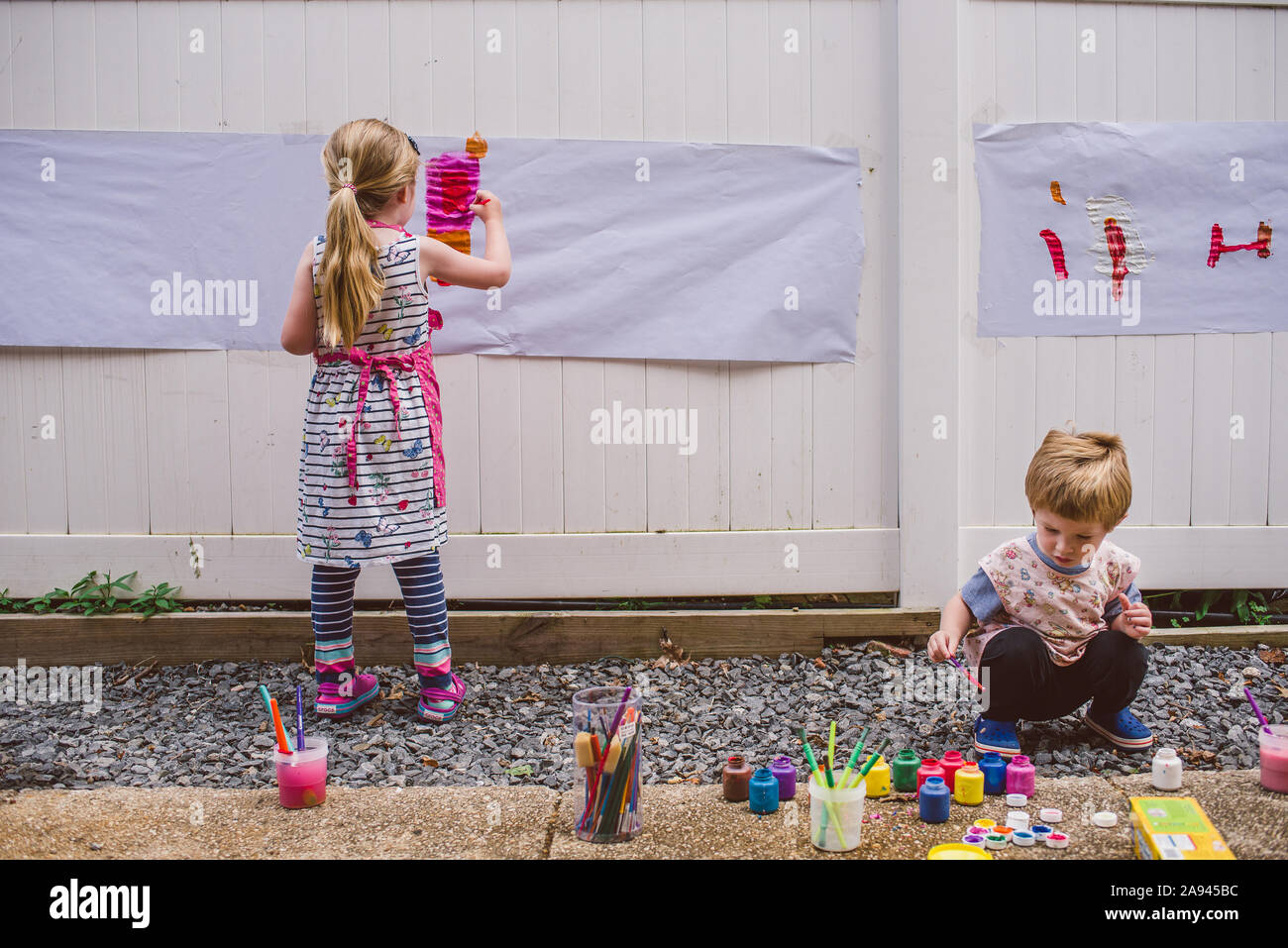 Two children paint outside Stock Photo - Alamy