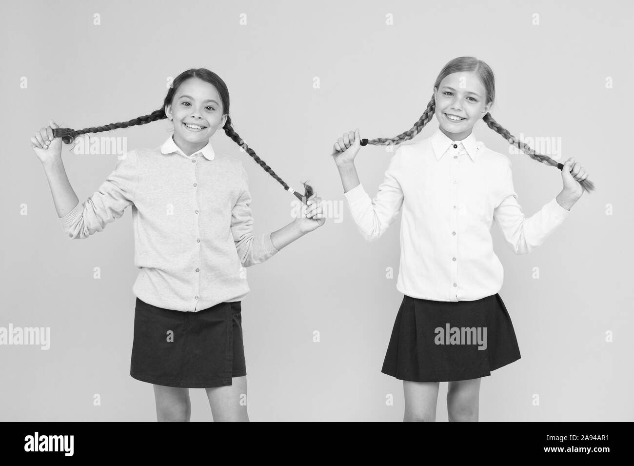 Having fun together. smart little girls on yellow background. kid ...