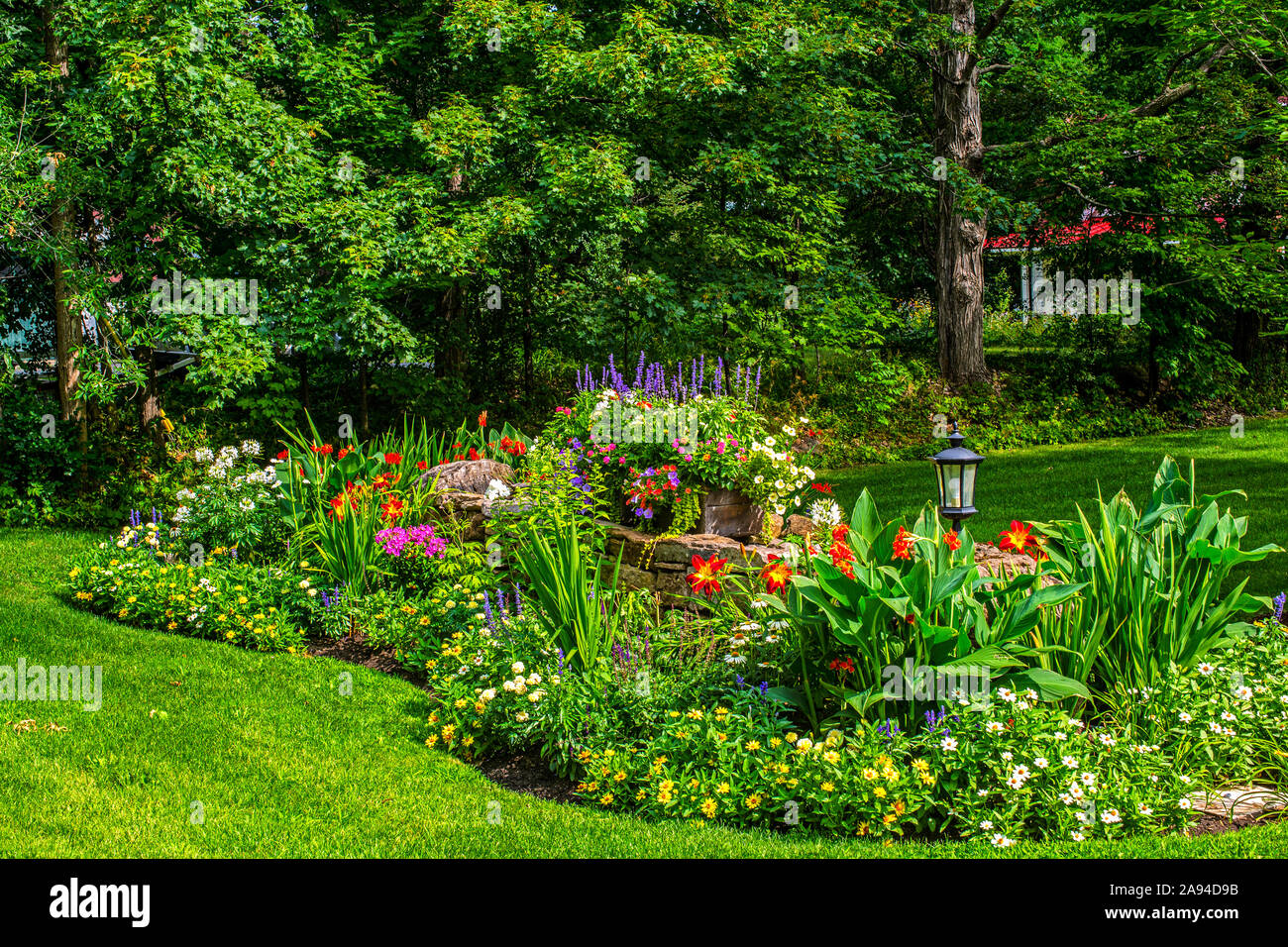 Landscaped flower garden in bloom in a yard; Hudson, Quebec, Canada ...