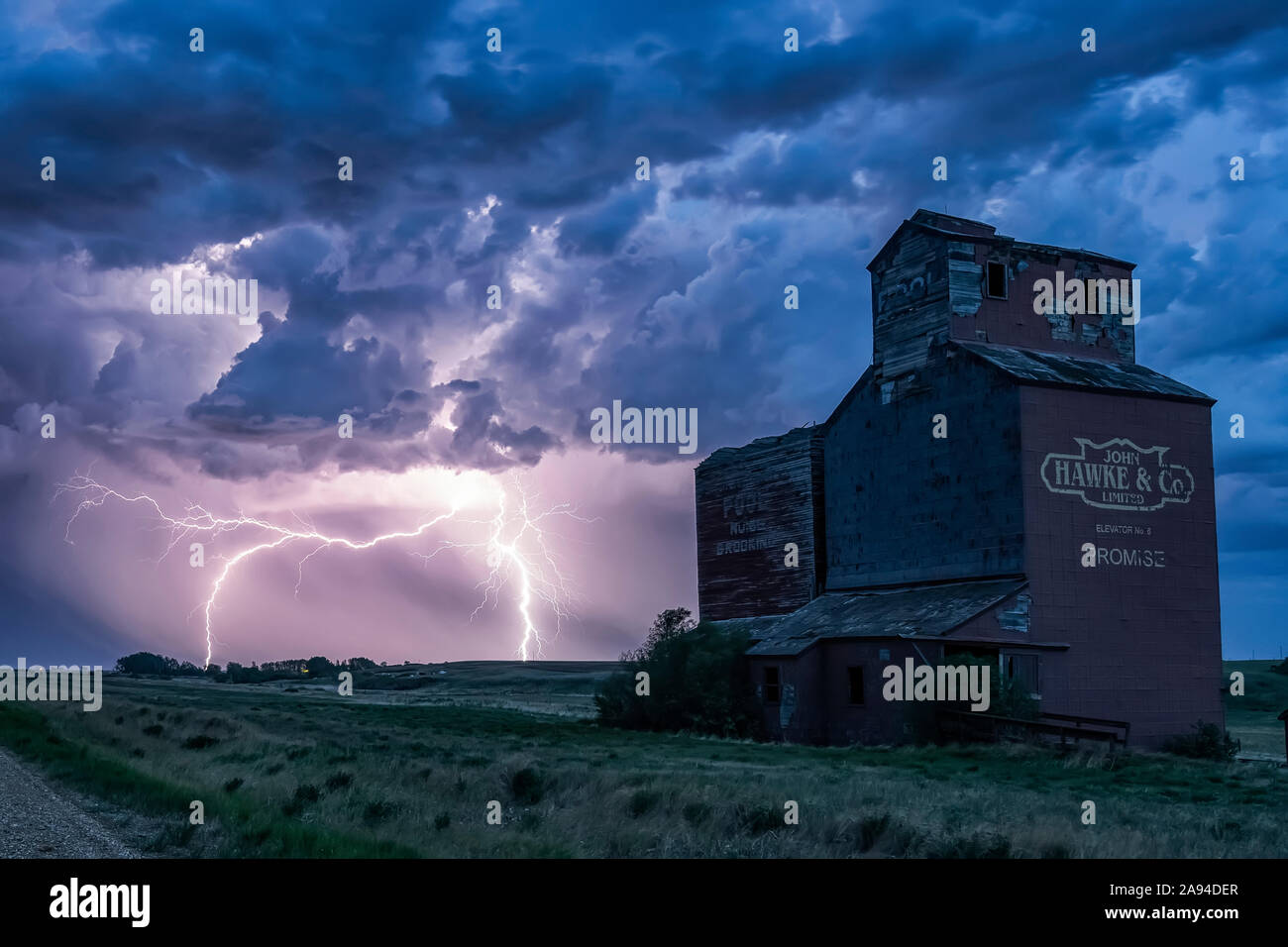 Grain elevator in a dramatic thunderstorm with dark clouds and ...