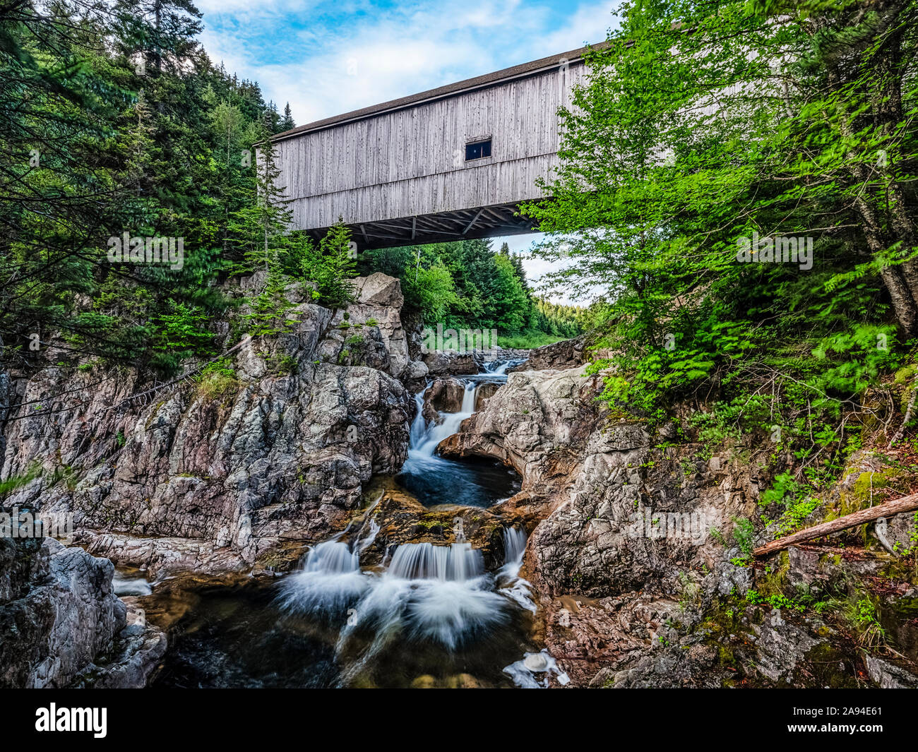 Historic covered bridge over waterfalls; Saint John, New Brunswick ...