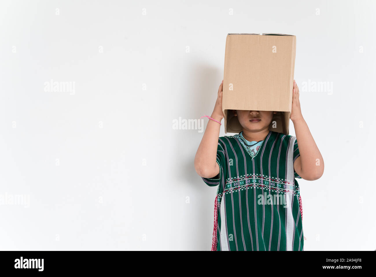 Young boy over isolated white background holding a box to move it to ...