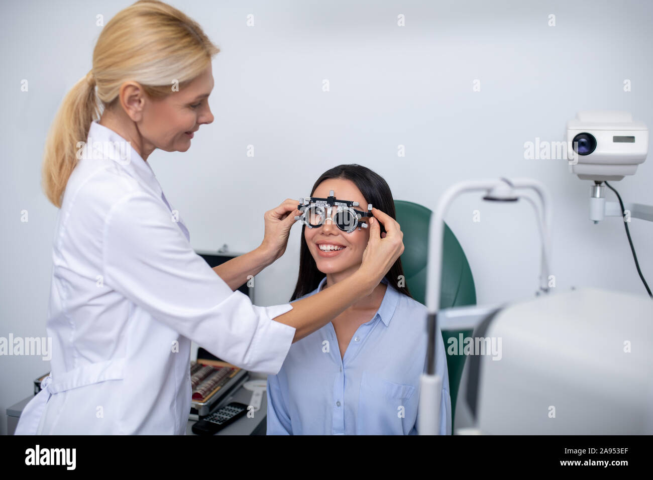 Making vision control. Blonde-haired professional eye doctor wearing ...