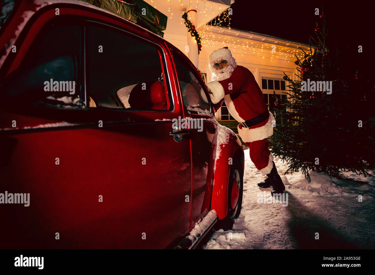 Santa is pushing a car stuck in the snow Stock Photo - Alamy