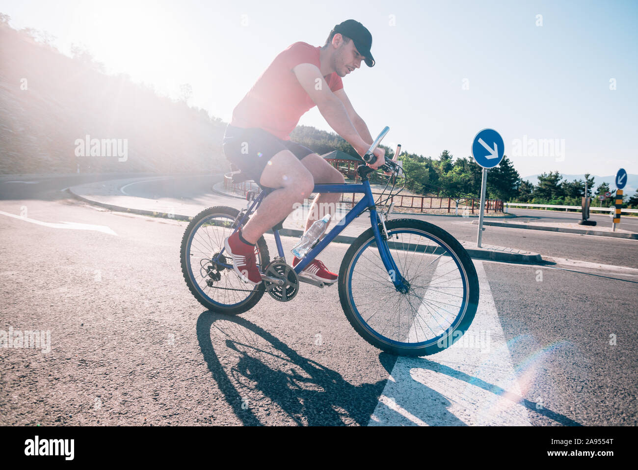 Fit male biker cyclist riding his bike cycle on an asphalt road at ...