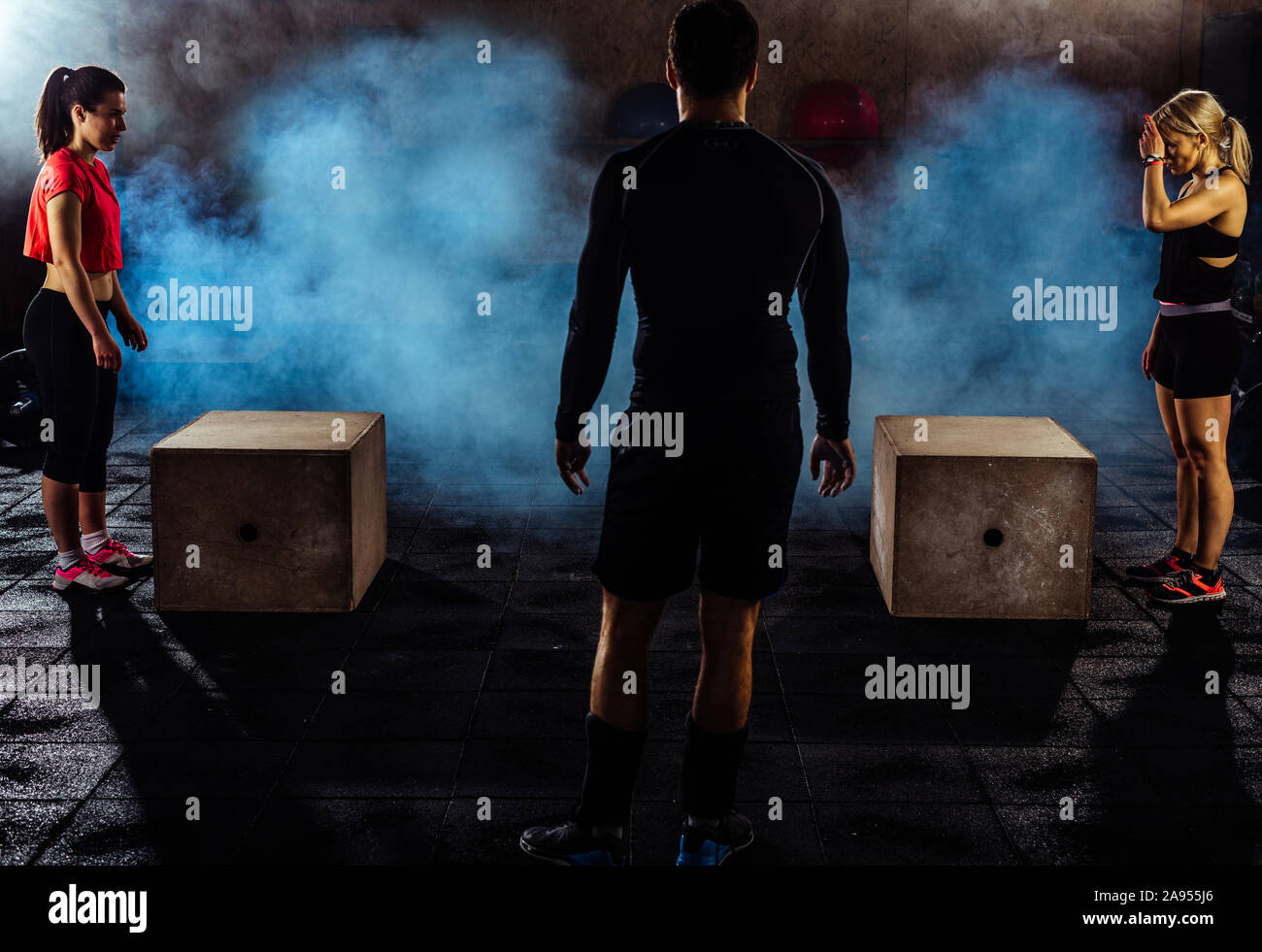 Crossfit class jumping on wooden boxes guided by trainer Stock Photo ...