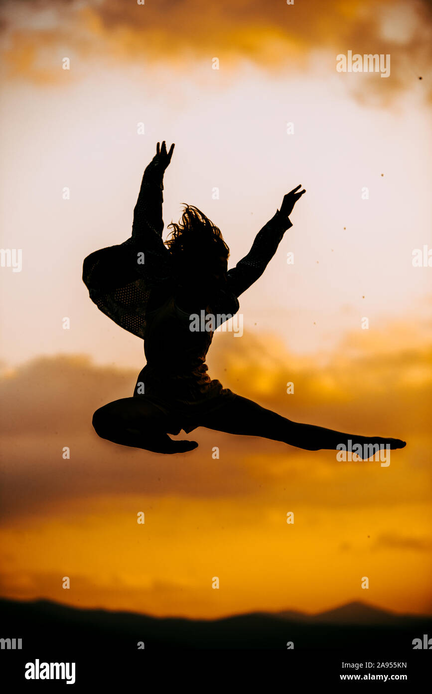 Side view of a full of energy woman dancer dancing and making a ...