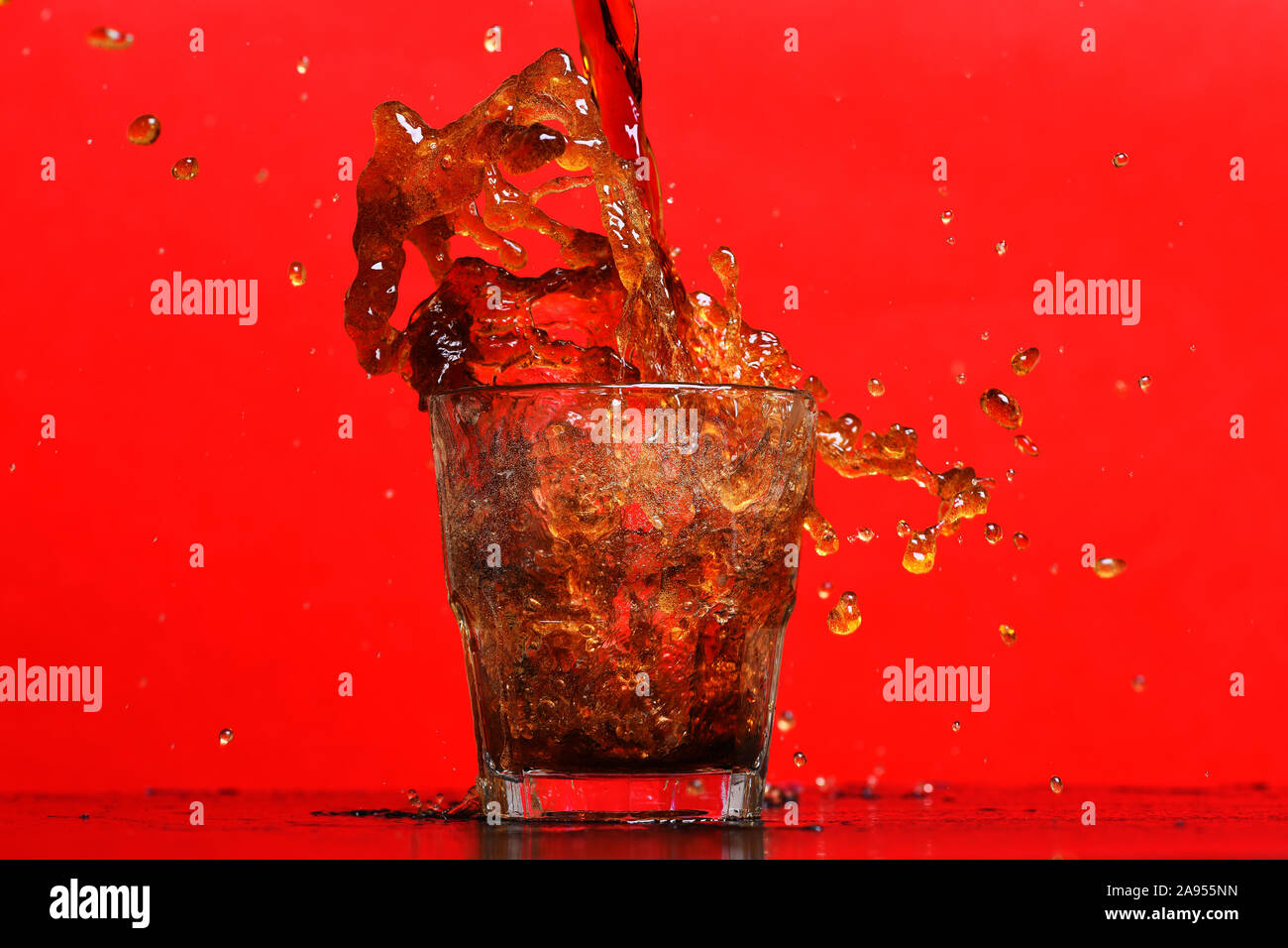 splash out drink from glass for whiskey on red background, side view ...