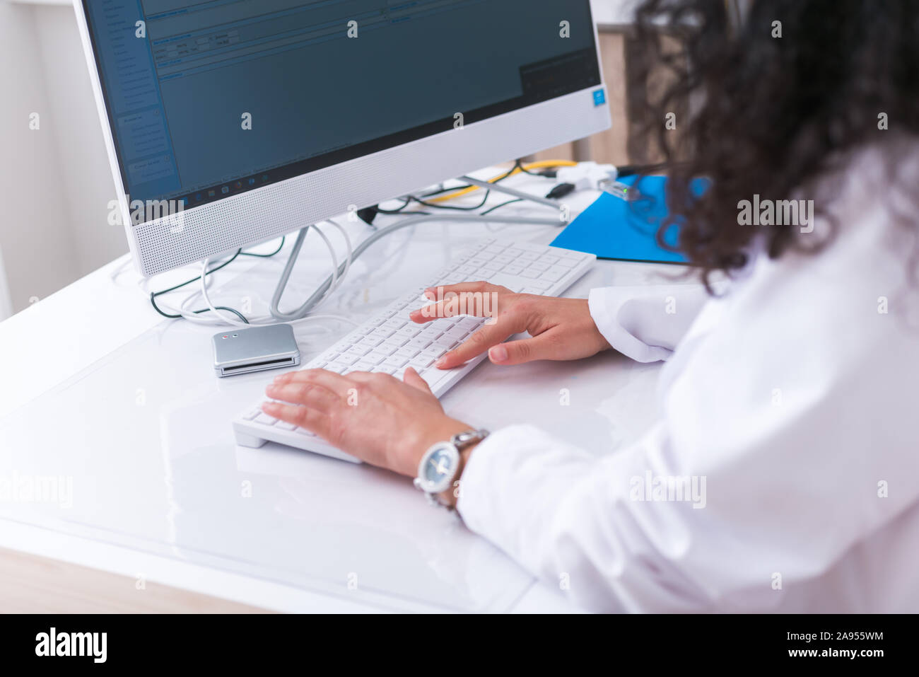 Close up hands of a female physician ( nurse ) typing on her white ...