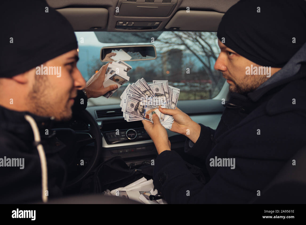 Two happy bank robbers celebrating their successful hit while sitting ...
