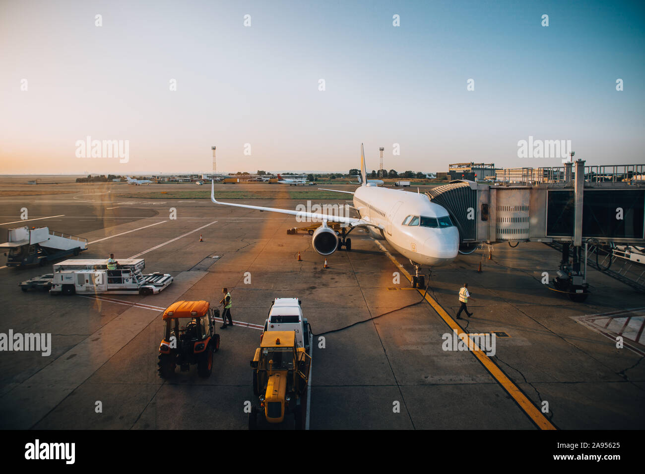 Multiple utility vehicles and an airplane during boarding process at an ...