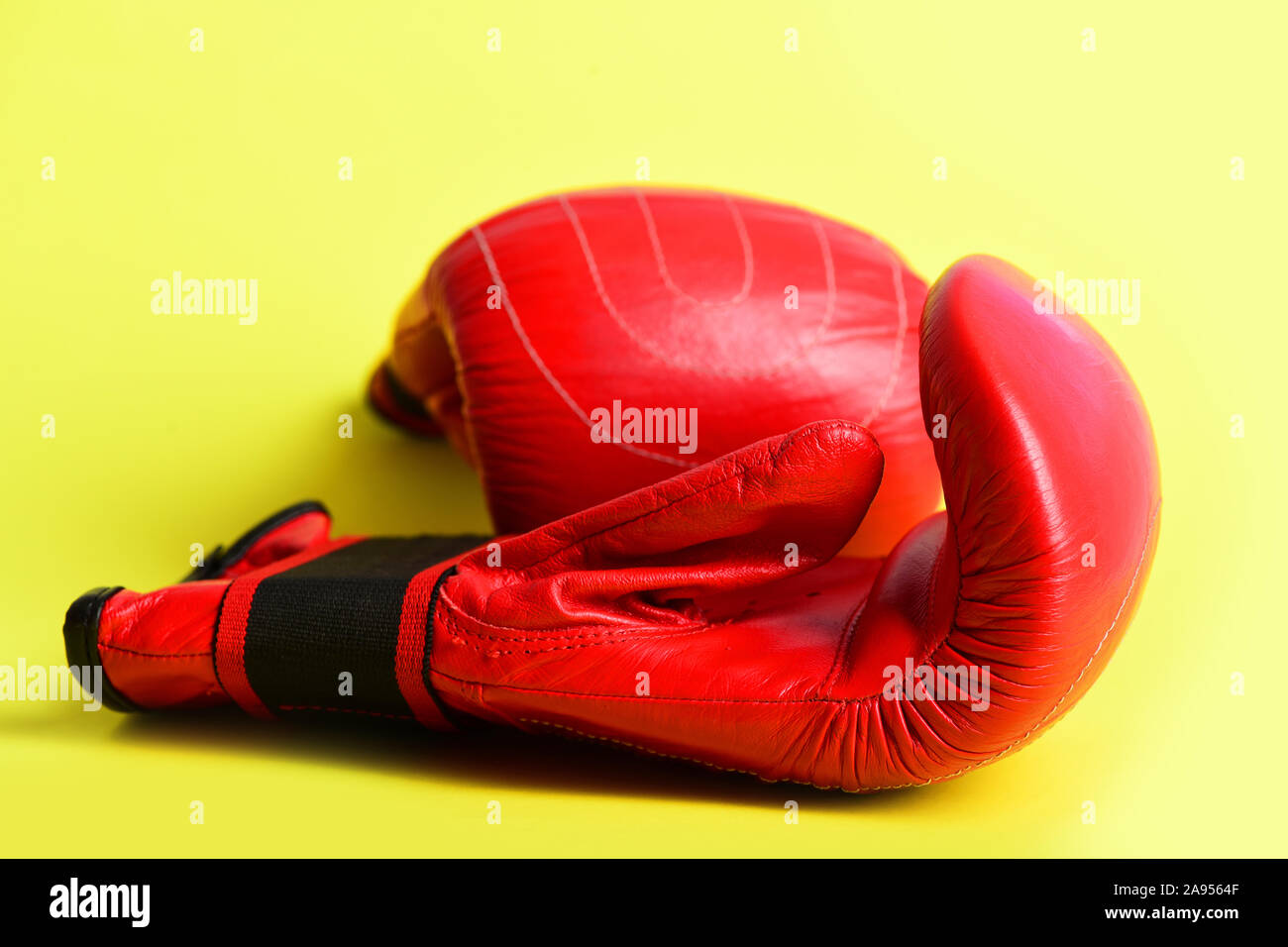 Red boxing gloves on juicy yellow background, close up. Concept of ...