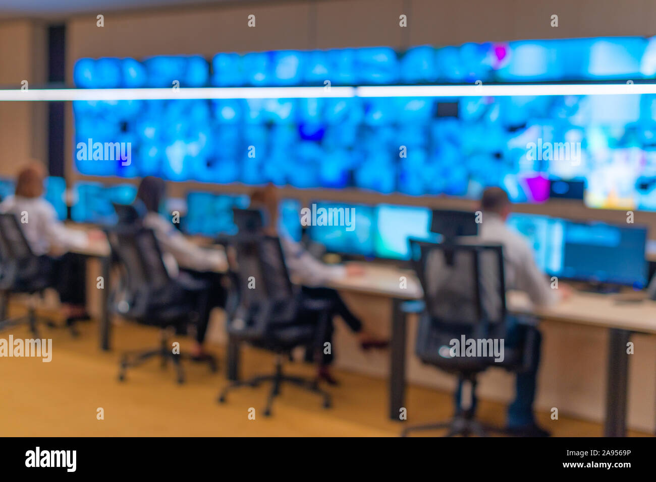 Blurred photo of security guards working on computers while sitting in ...