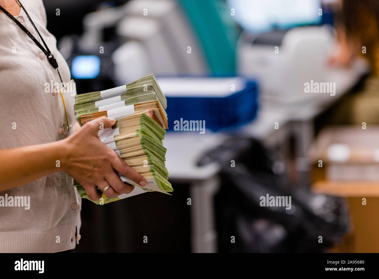 Counting person handling stacks of euro € cash sorted with bill bands ...