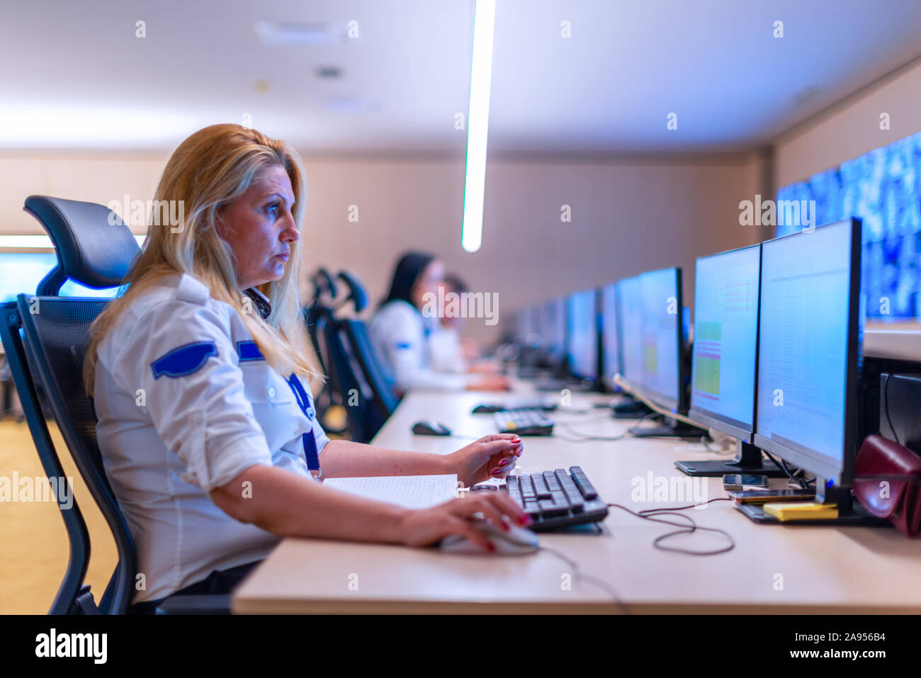 Female security operator working in a security data control room ...