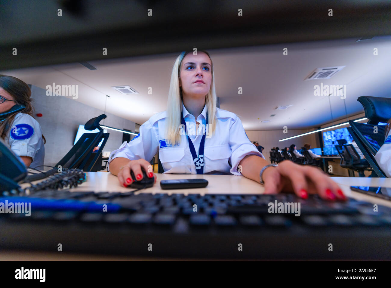 Female security operator working in a security data control room ...