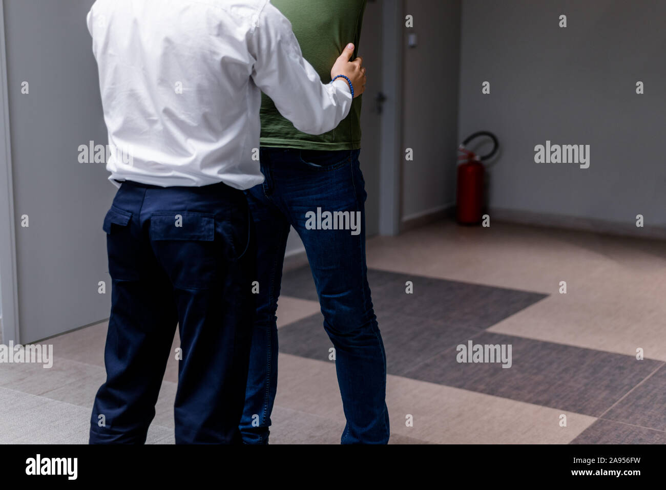 Man being body searched for hidden objects by a guard at security ...