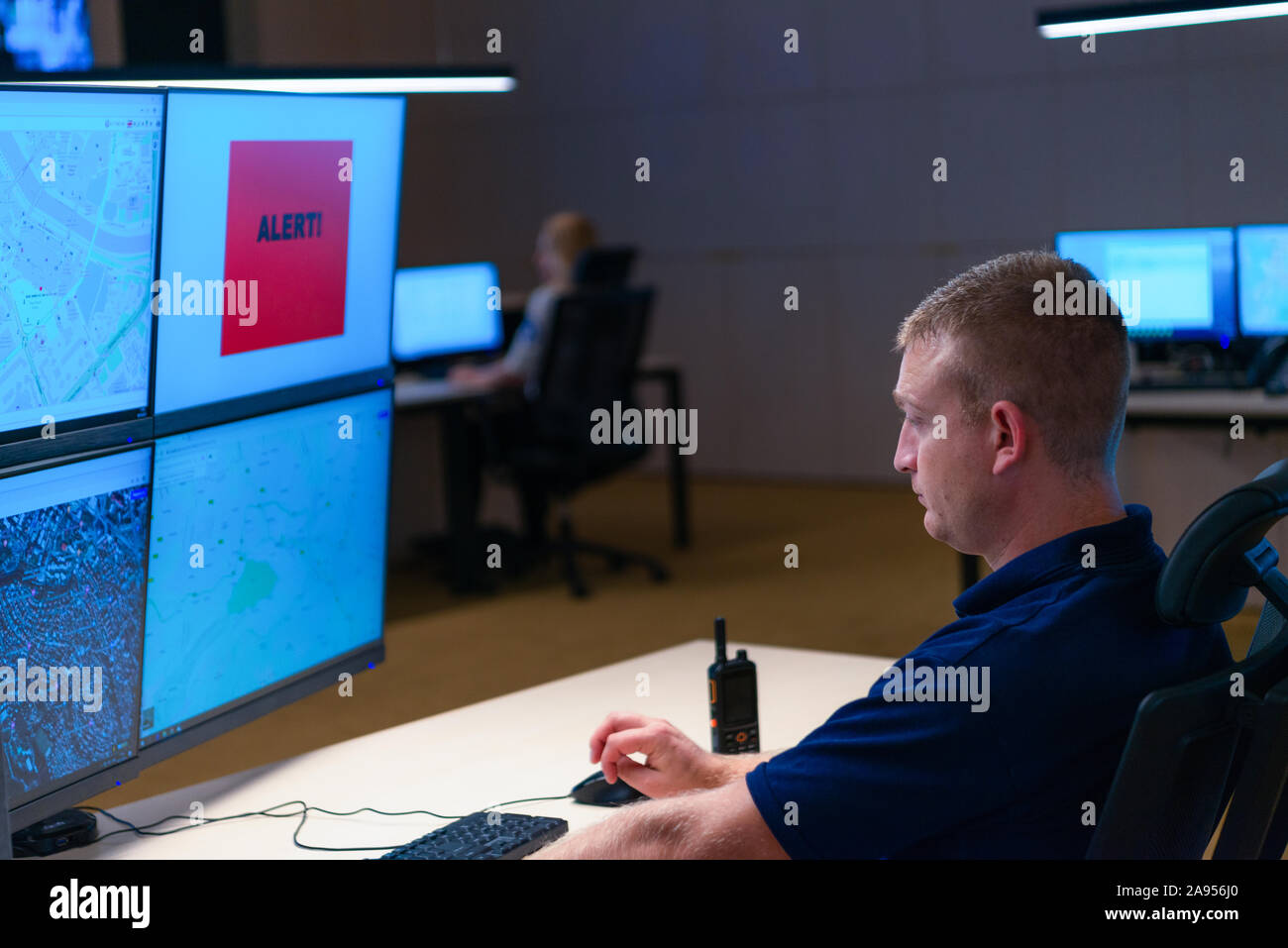 In the Security Control Room Officer Monitors Multiple Screens while ...