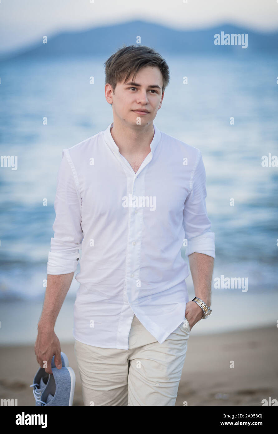 Outdoor portrait of a handsome young man walking near the sea Stock ...