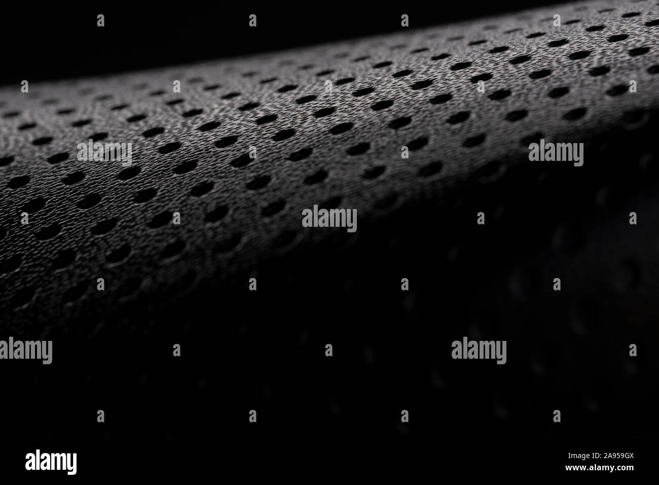 Macro image of the texture of a black bicycle seat against a black ...