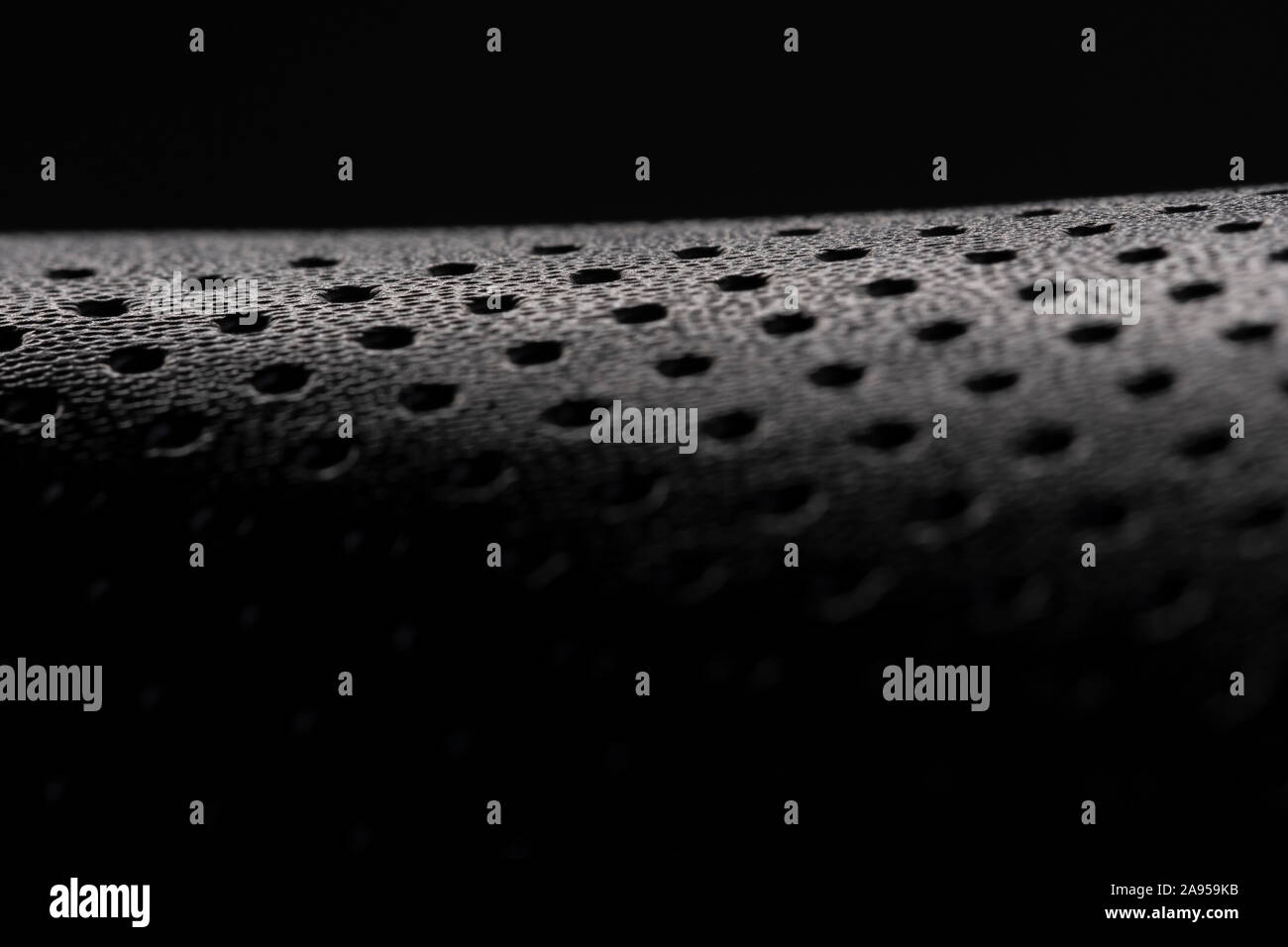 Macro image of the texture of a black bicycle seat against a black ...