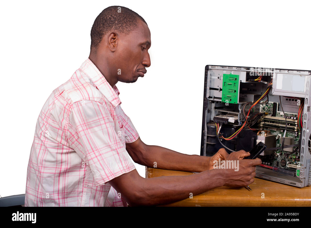 young technician sitting thinking with a desktop computer in front of ...