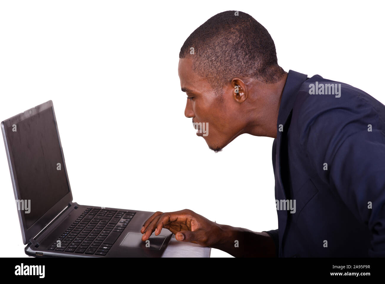 young businessman looking at his computer screen and absorbed by the ...