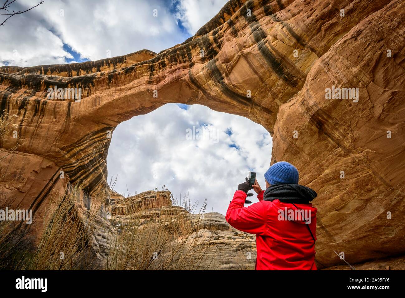 Tourist photographs rock arch, Sipapu Bridge, Natural Bridges National ...