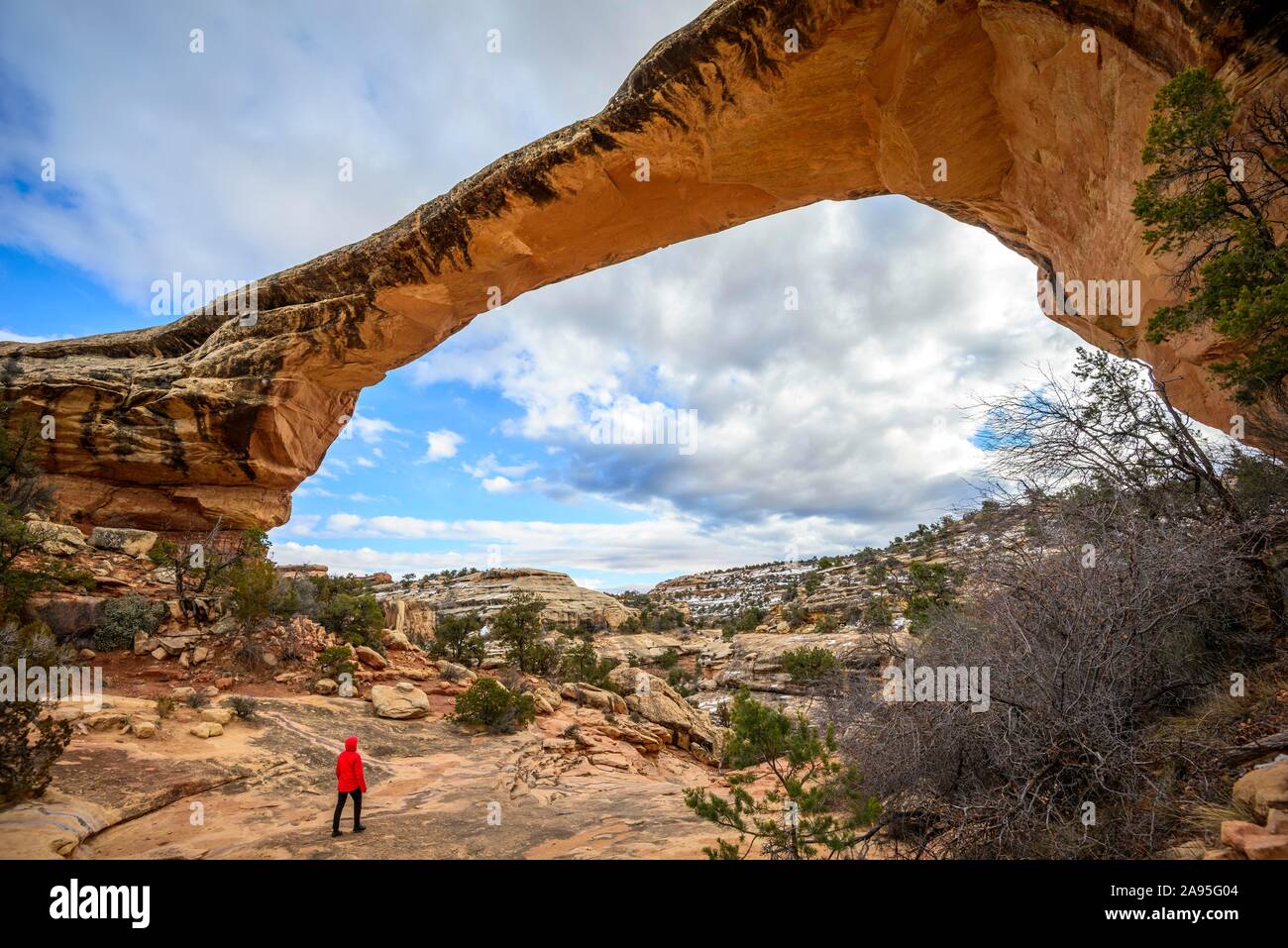 Tourist under rock arch, Owachomo Bridge, Natural Bridges National ...