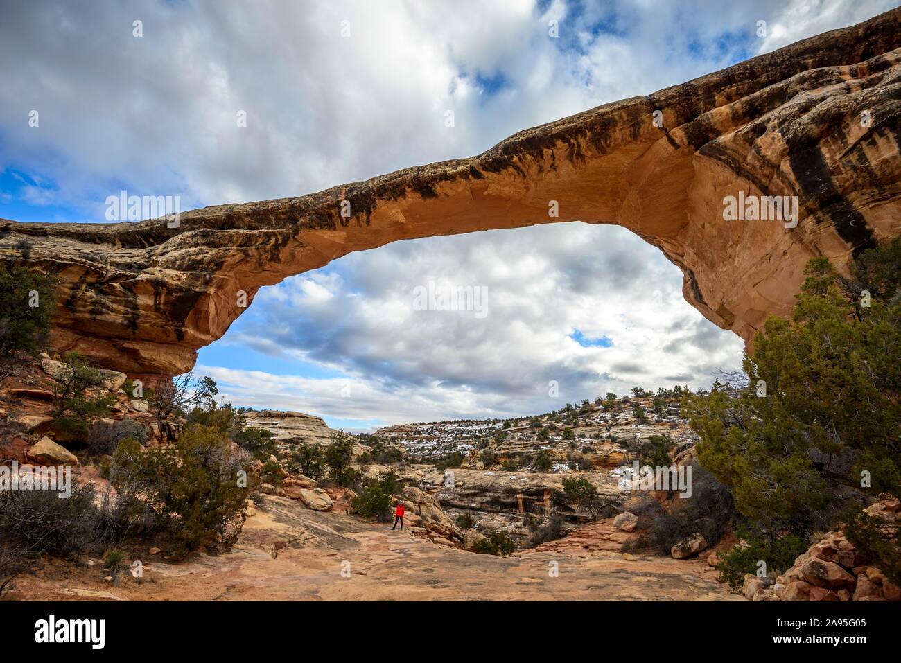 Tourist under rock arch, Owachomo Bridge, Natural Bridges National ...