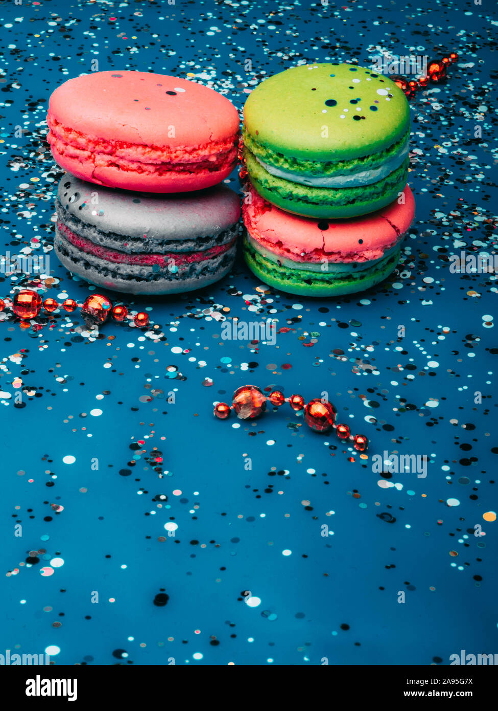 Tasty colorful macaroons on festive dark blue background with confetti ...