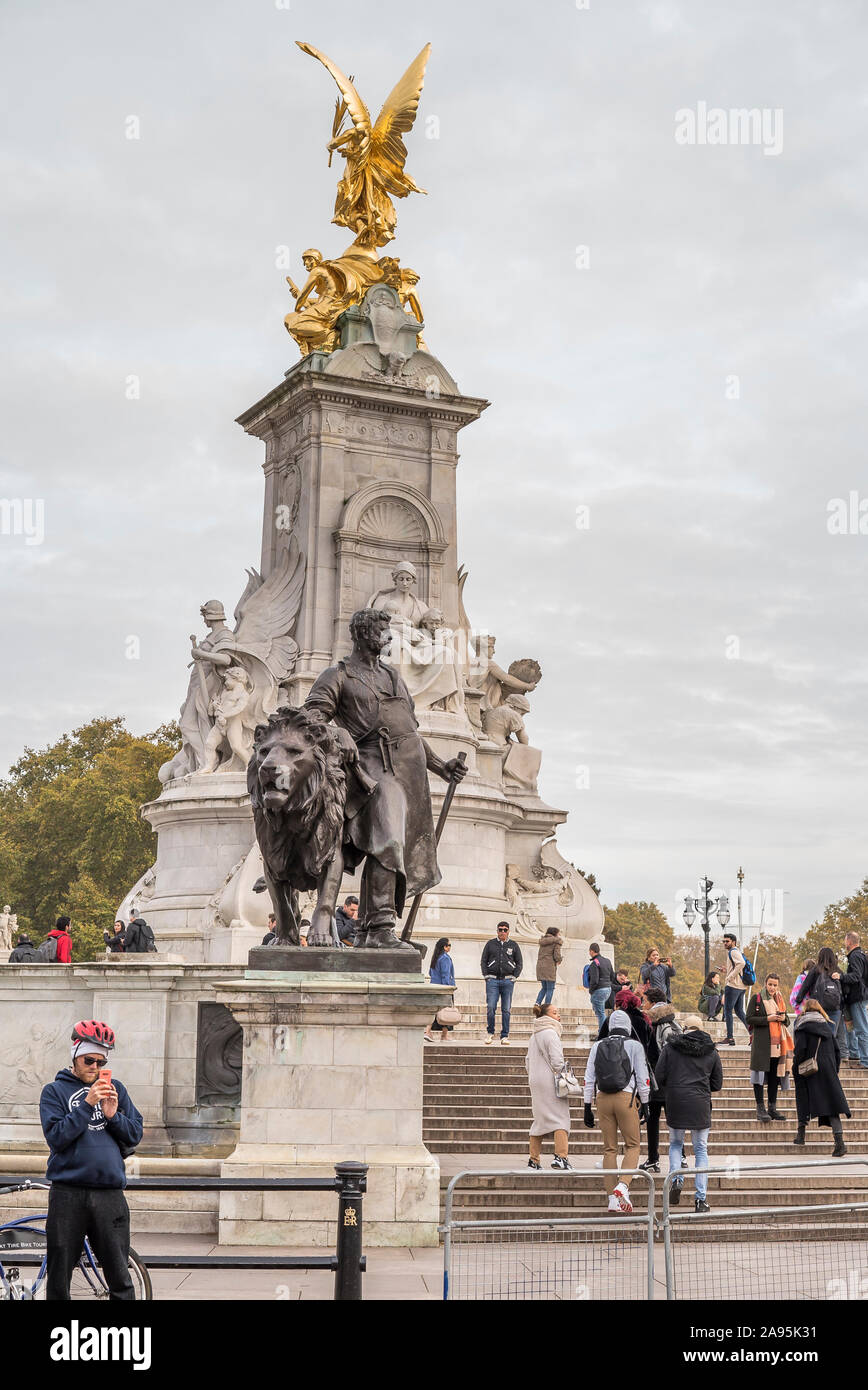 Portrait shot of UK tourists visiting Queen Victoria Memorial statue ...