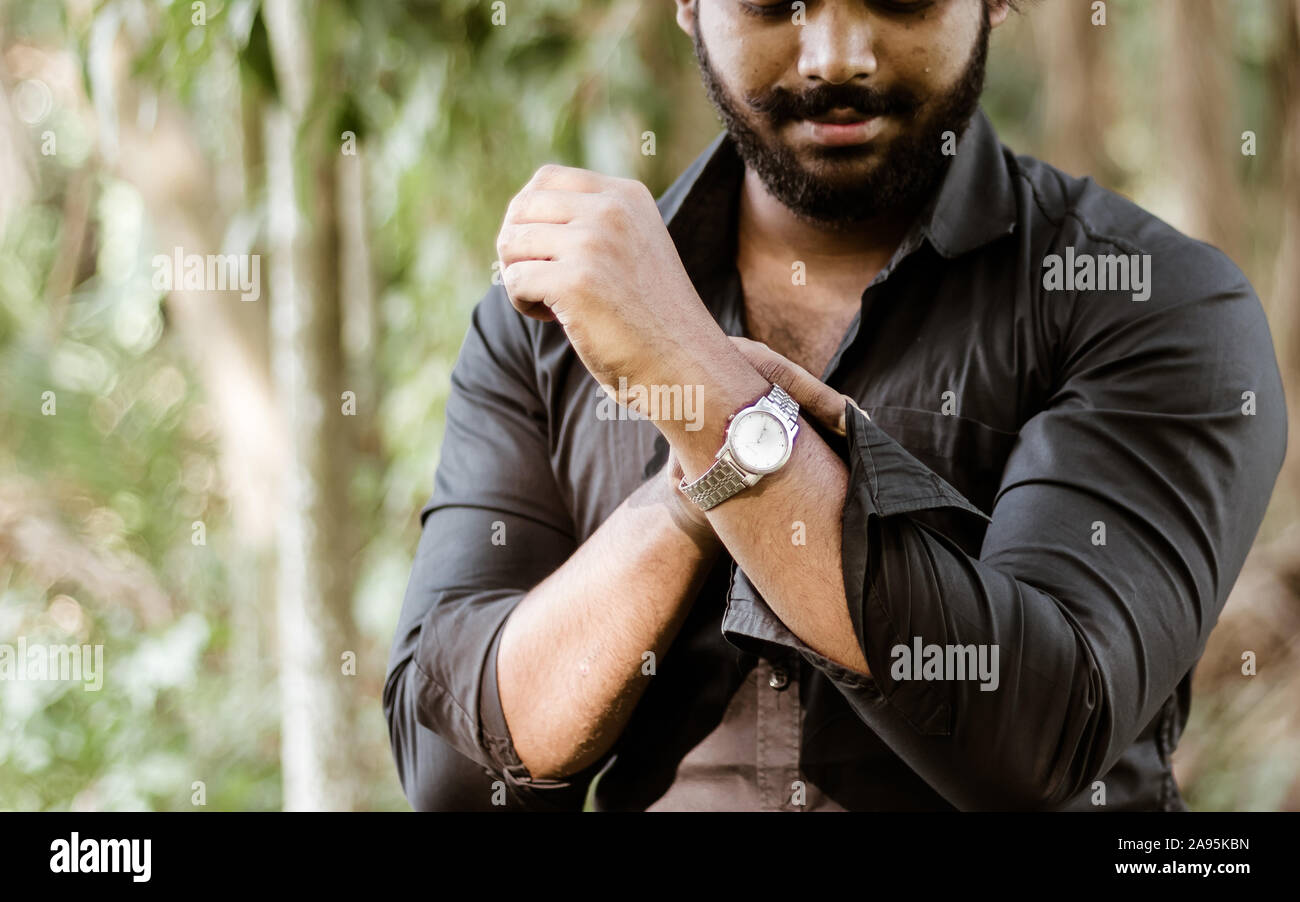 Portrait of Cropped Well-dressed man wearing wristwatch and rolling up ...