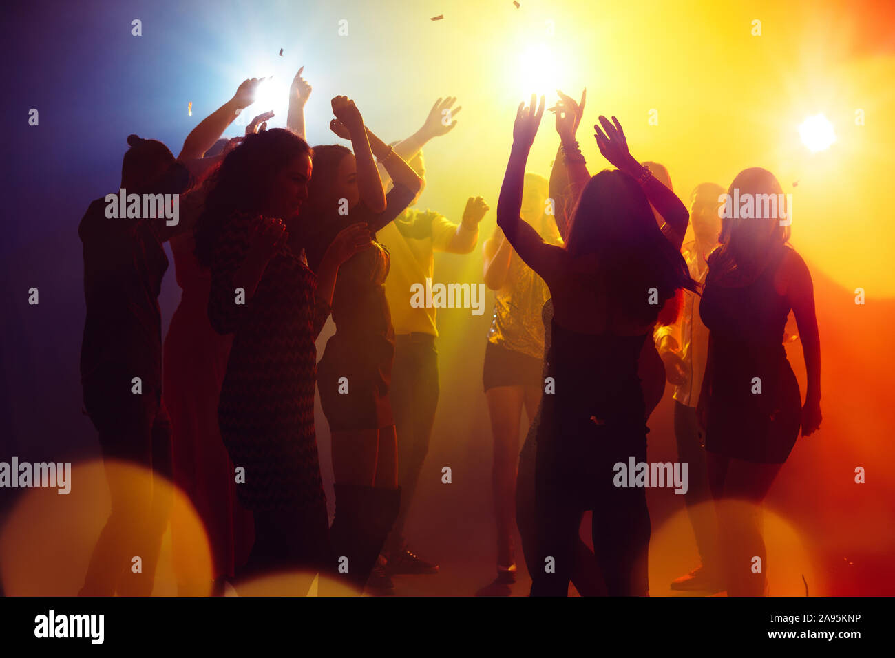 Holidays. A crowd of people in silhouette raises their hands on ...
