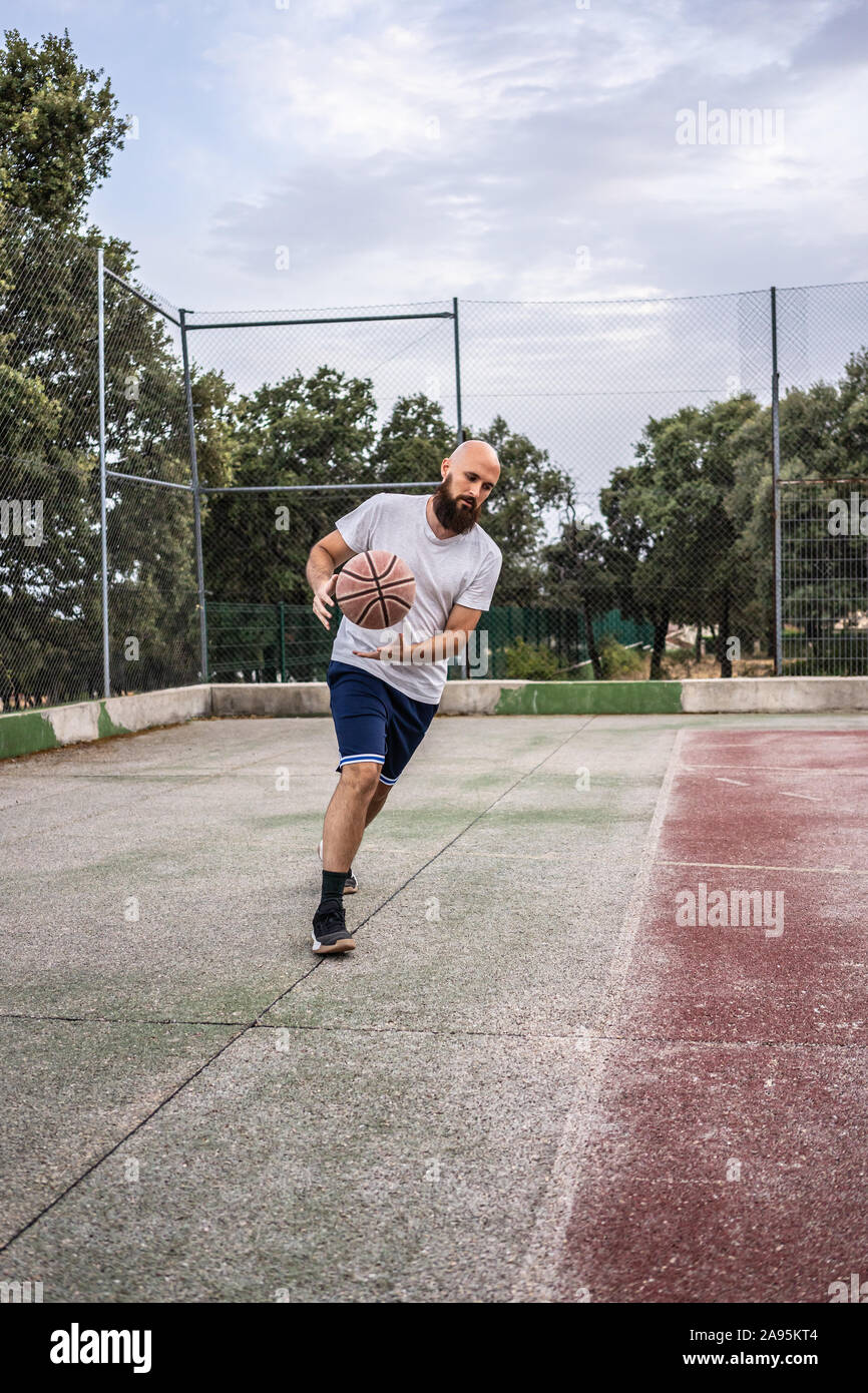Young basketball player receiving the ball, on an old basketball court ...