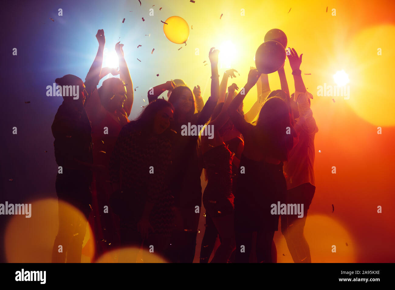 Memories. A crowd of people in silhouette raises their hands on ...